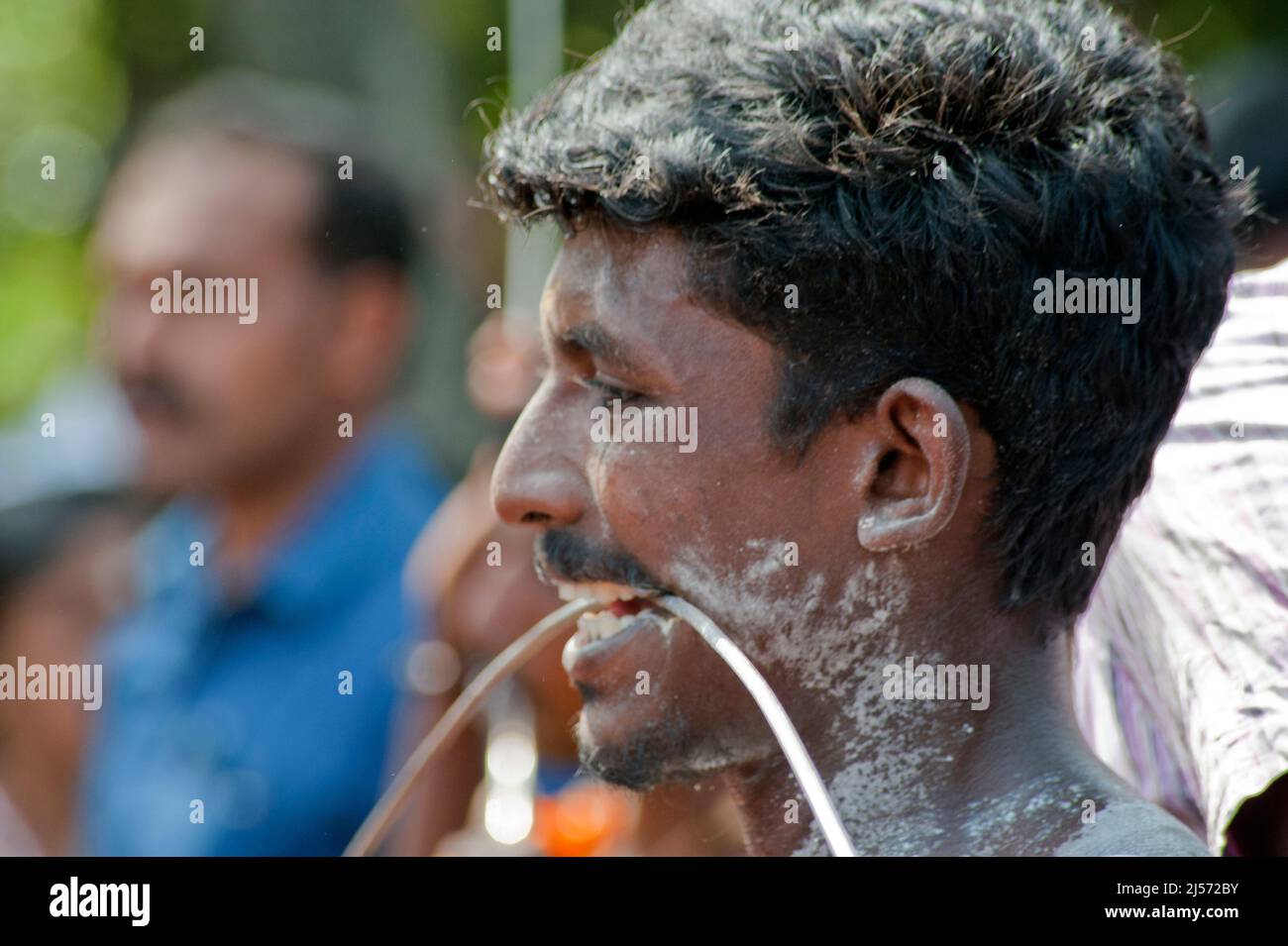 Man piercing spikes through cheeks discharging vow in Thaipusam ...