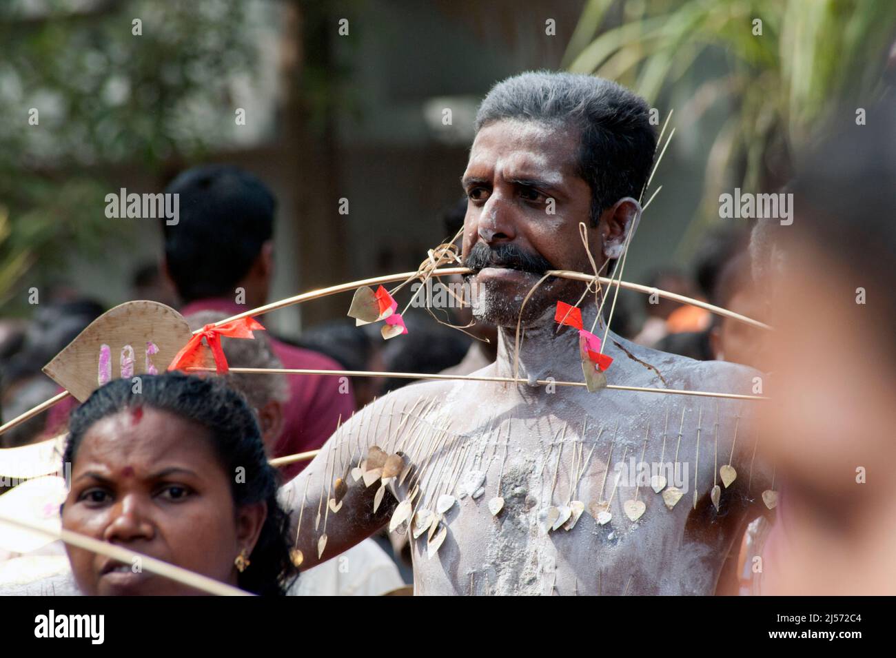 Man piercing spikes through cheeks discharging vow in Thaipusam ...