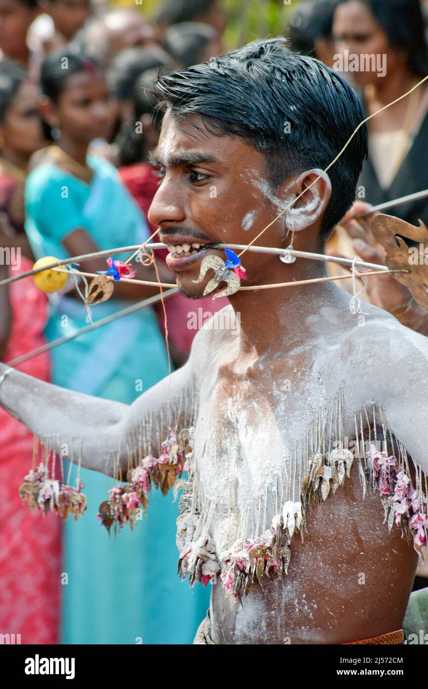 Man piercing spikes through cheeks discharging vow in Thaipusam ...