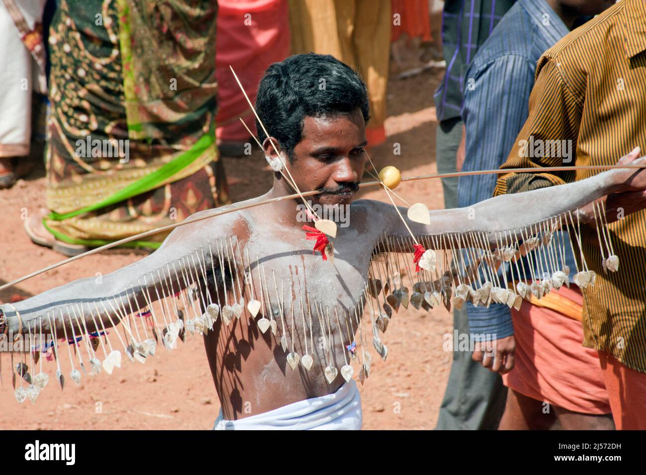 Man piercing spikes through cheeks discharging vow in Thaipusam ...