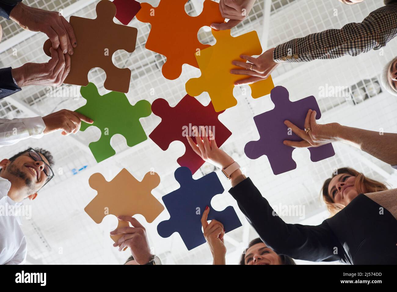 Business team joining jigsaw puzzle pieces and suggesting creative ...