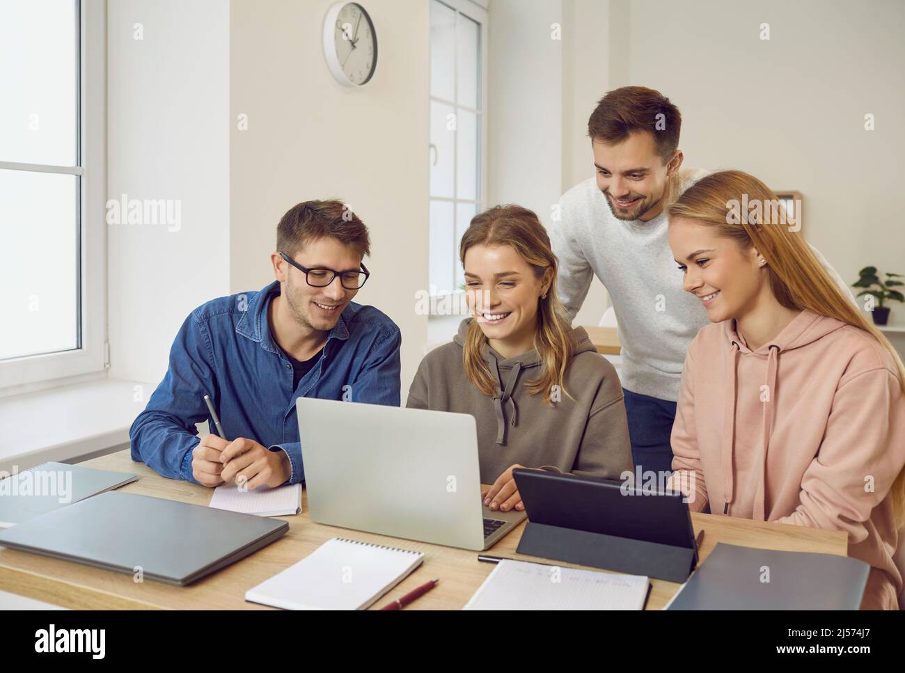Smiling students work together on computer online Stock Photo - Alamy