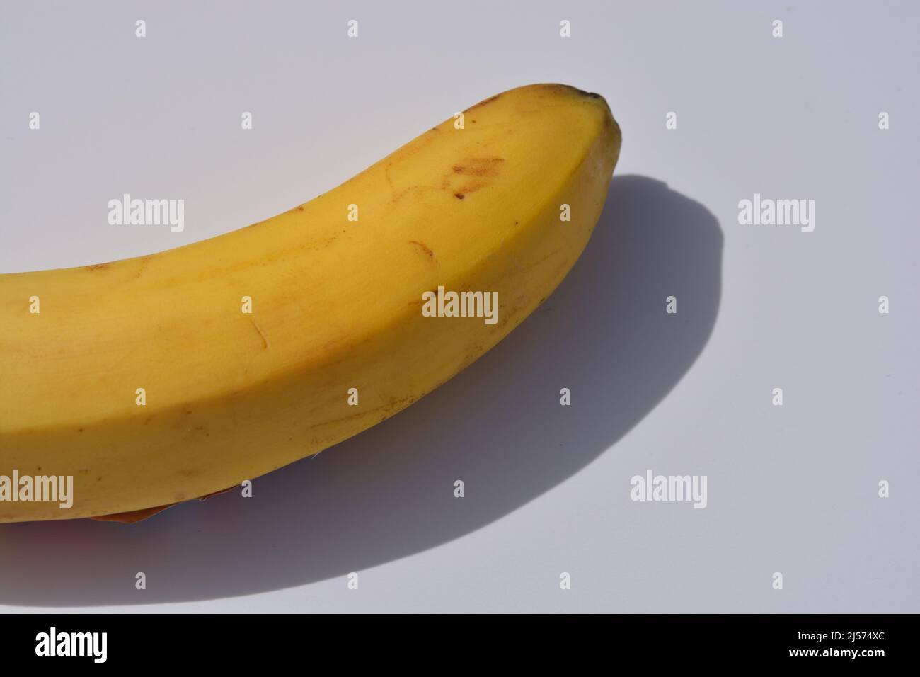 banana with a strong shadow on a white background in the sun in the ...