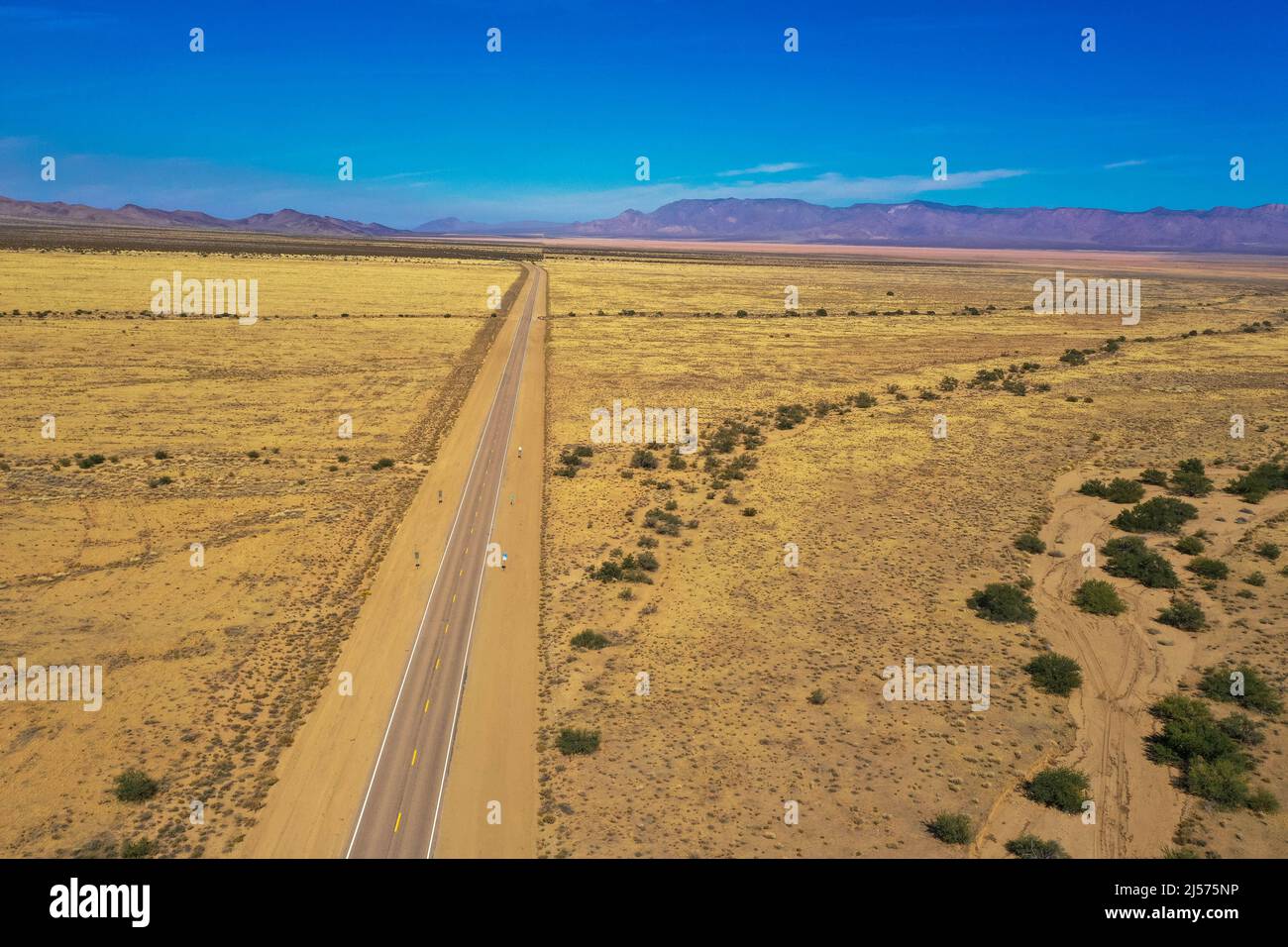 Desert landscape with brown orange colored sand and country road ...