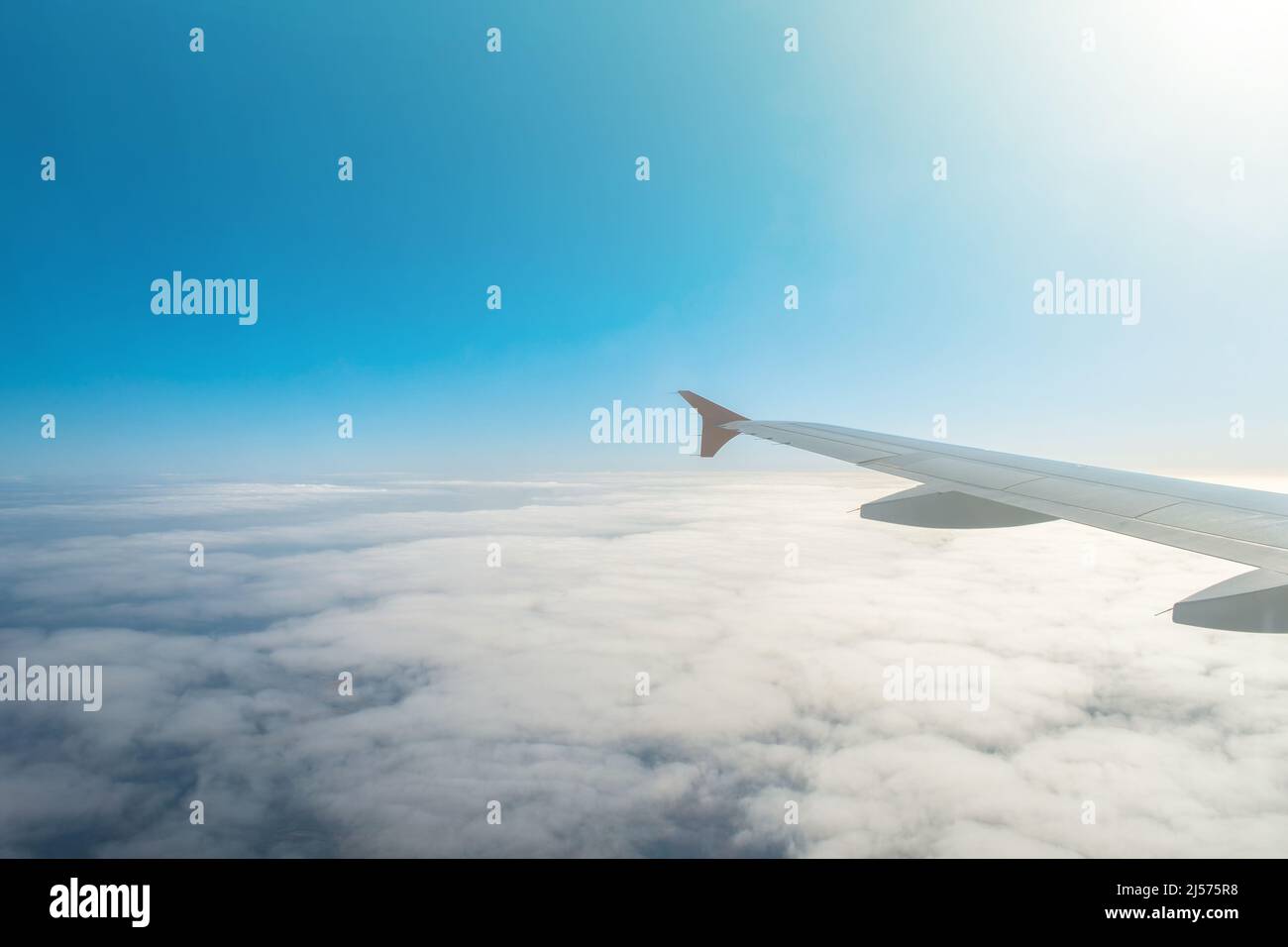 Wing view of the airplane, fluffy clouds on the skyline during climbing ...