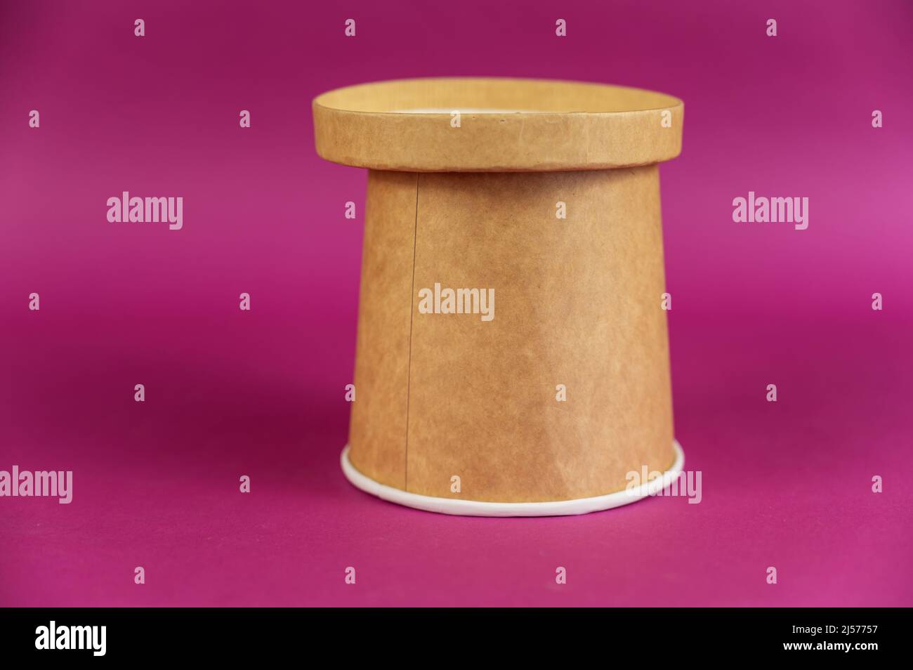 Empty cylindrical paper container with lid opposite-colored background ...