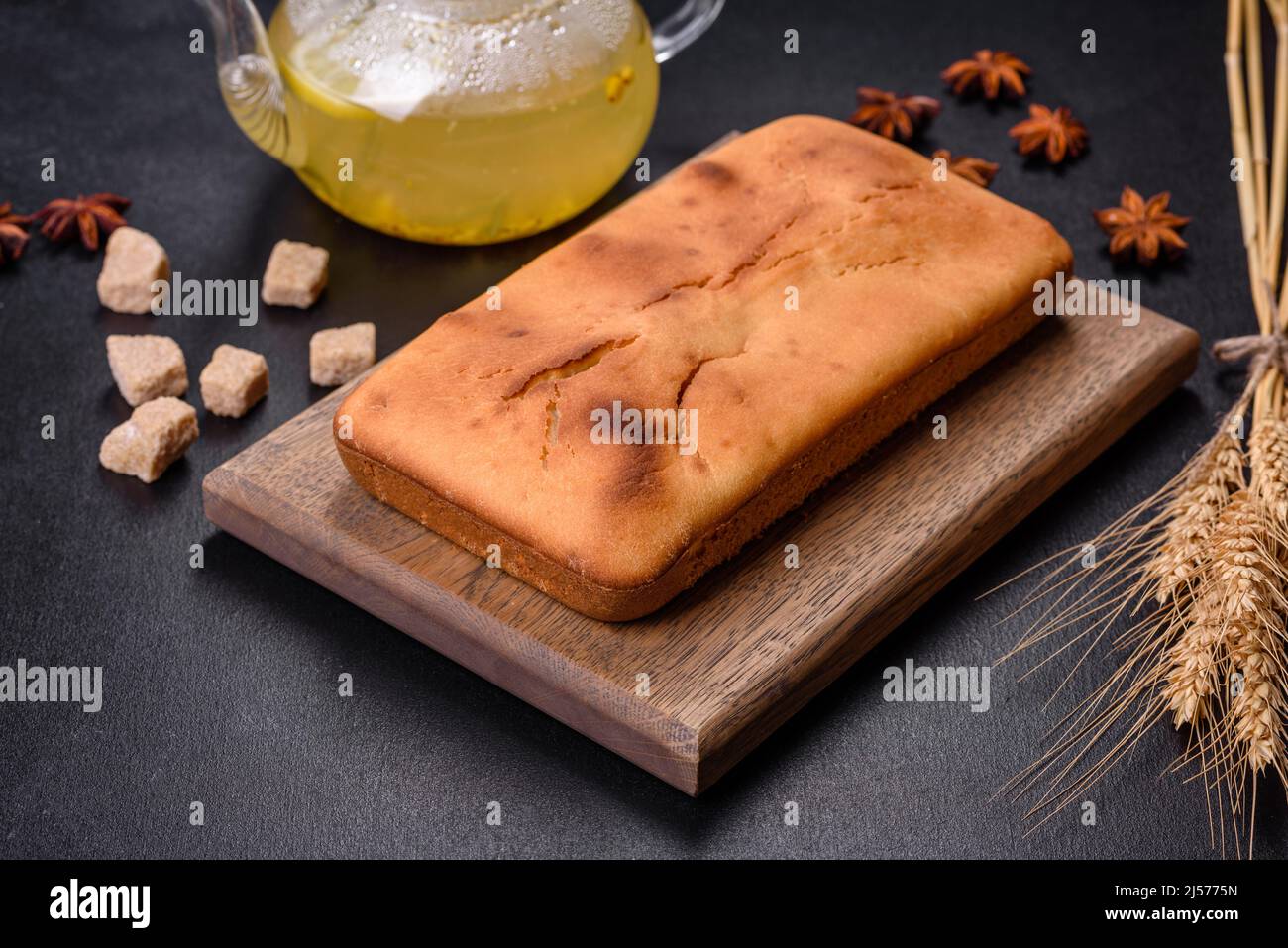 Baked rectangular cupcake with raisins and chocolate on a dark concrete ...