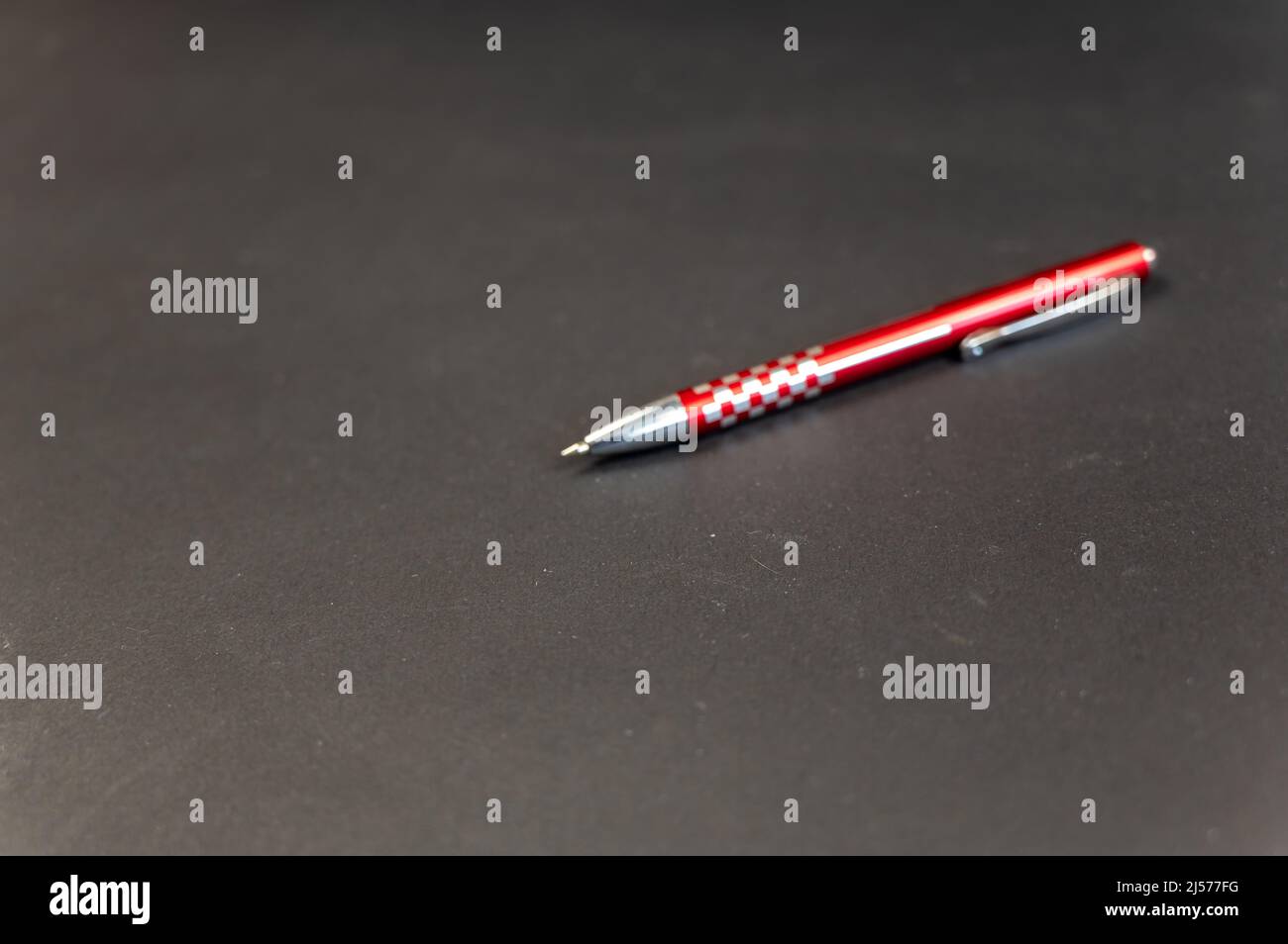 Defocused shot Silver-red pen on black background. Ballpoint pen with ...