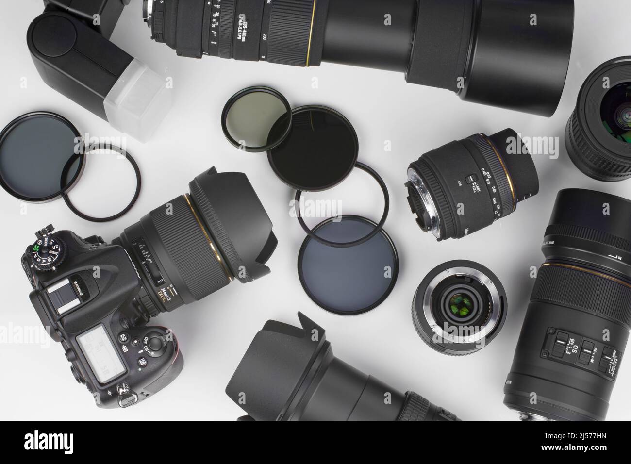 Modern SLR camera with various lenses, flash unit and filters, top view ...
