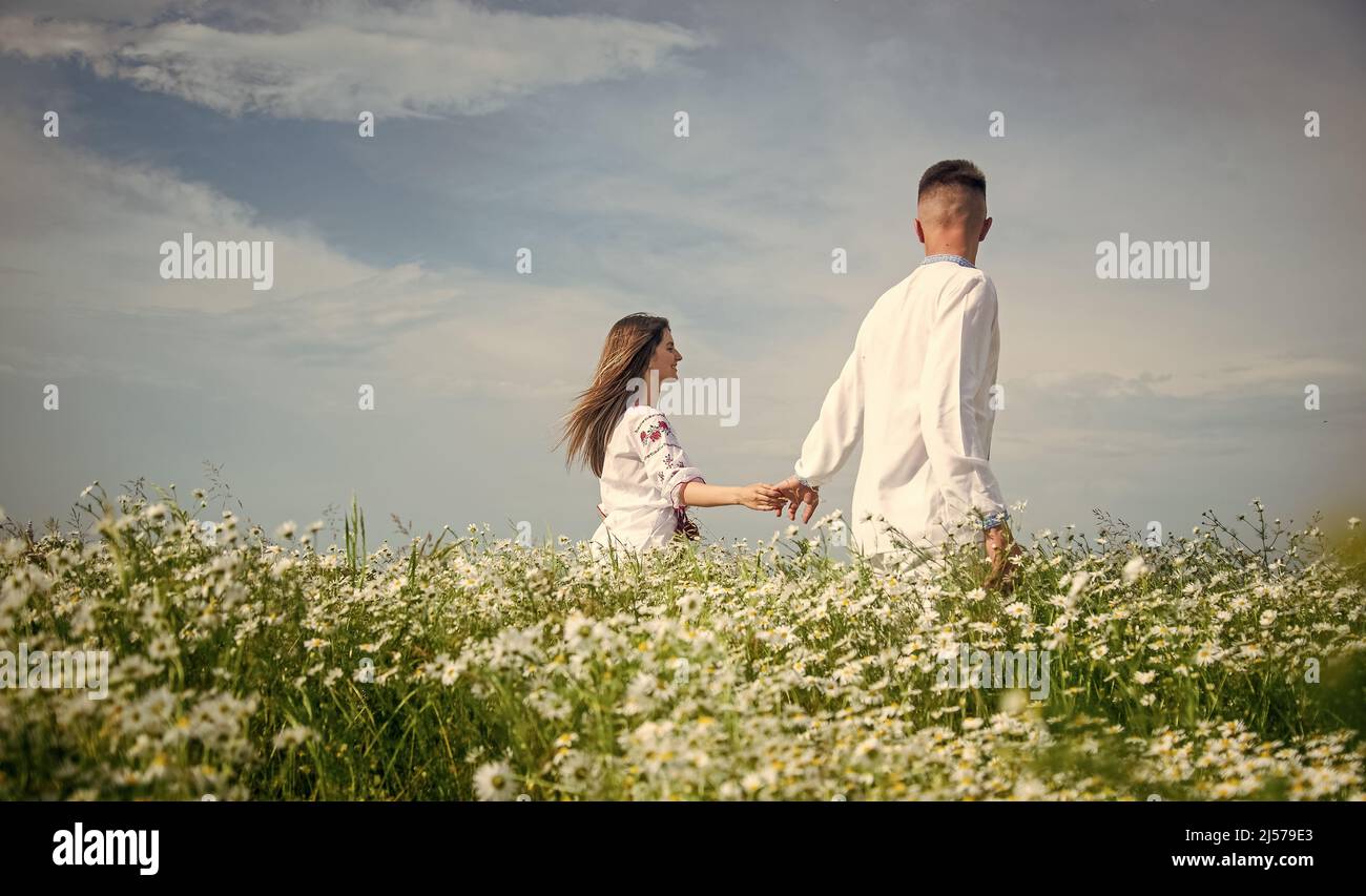 Couple walking in poppy field holding hands smiling, love and romance ...
