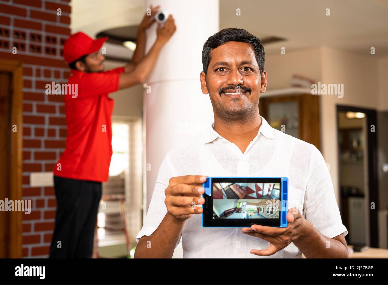 House owner showing cctv camera footage on tablet in front of ...