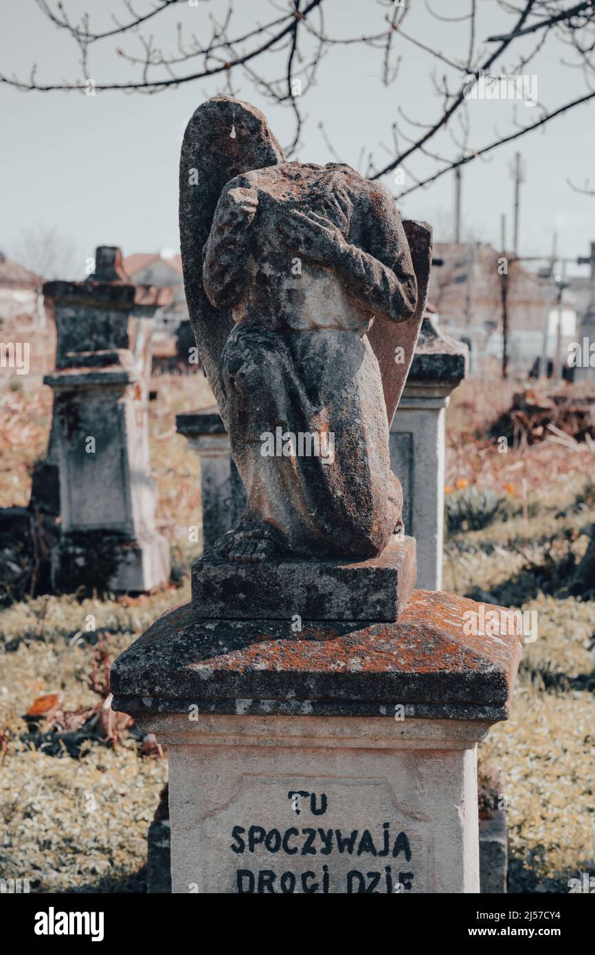 Damaged gravestone, beheaded stone angel sculpture at abandoned ancient ...