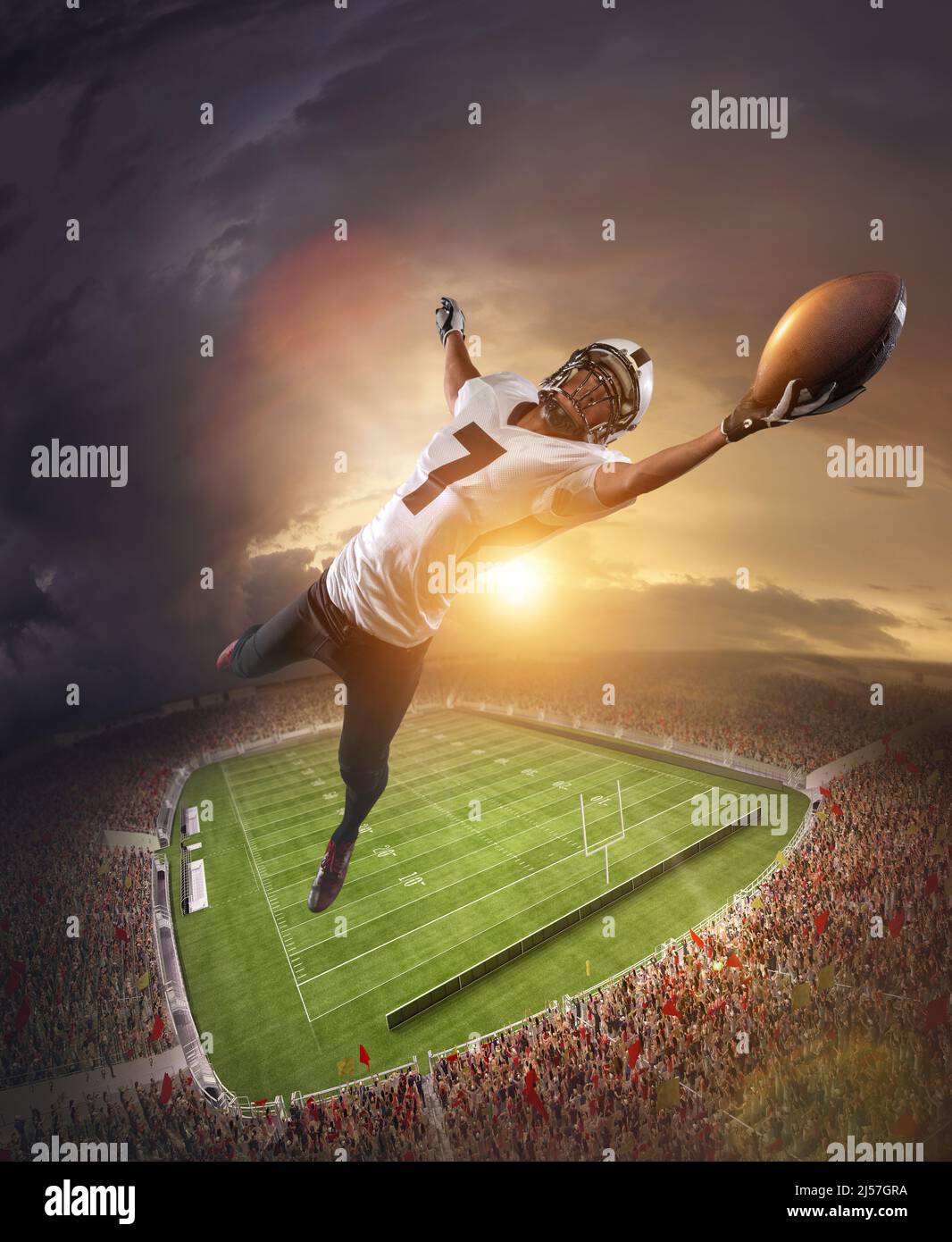 American football players catching ball in flight overt stadium with ...