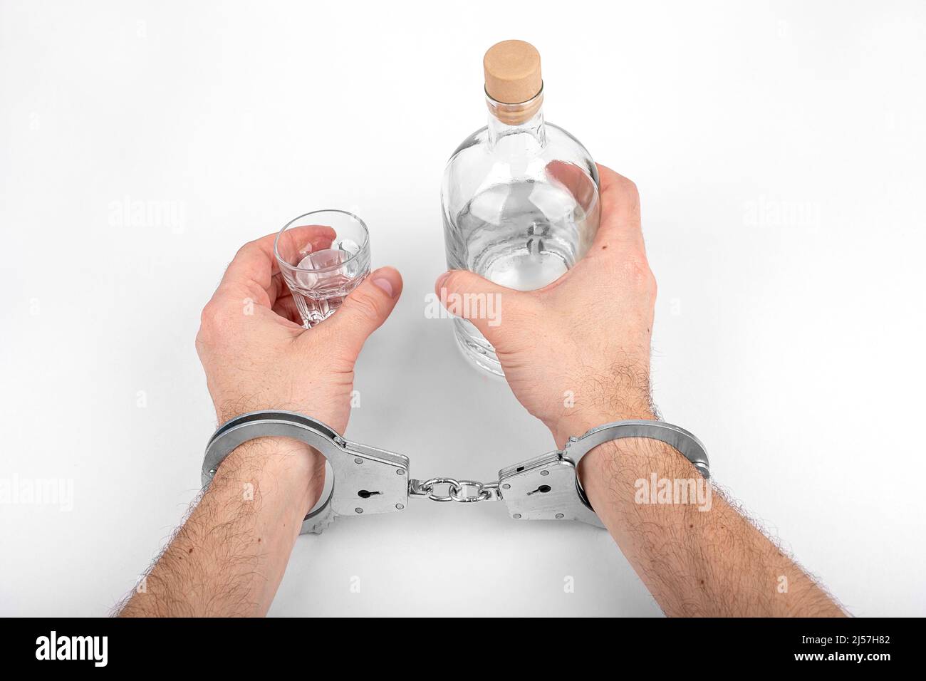 The concept of male alcohol addiction. Handcuffed hands holding a ...