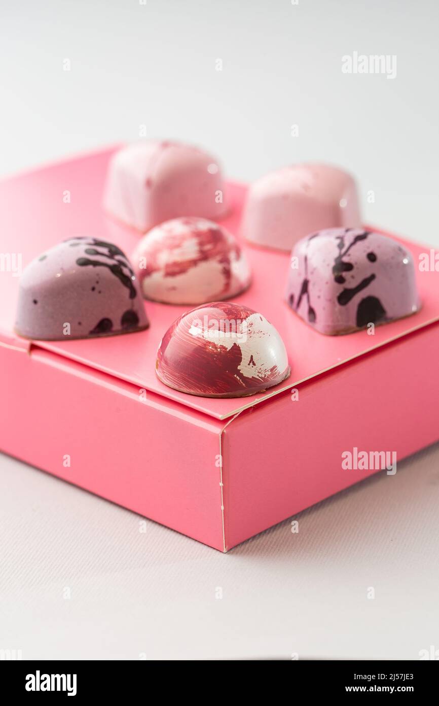 Luxury handmade chocolate candy on pink box isolated on white ...