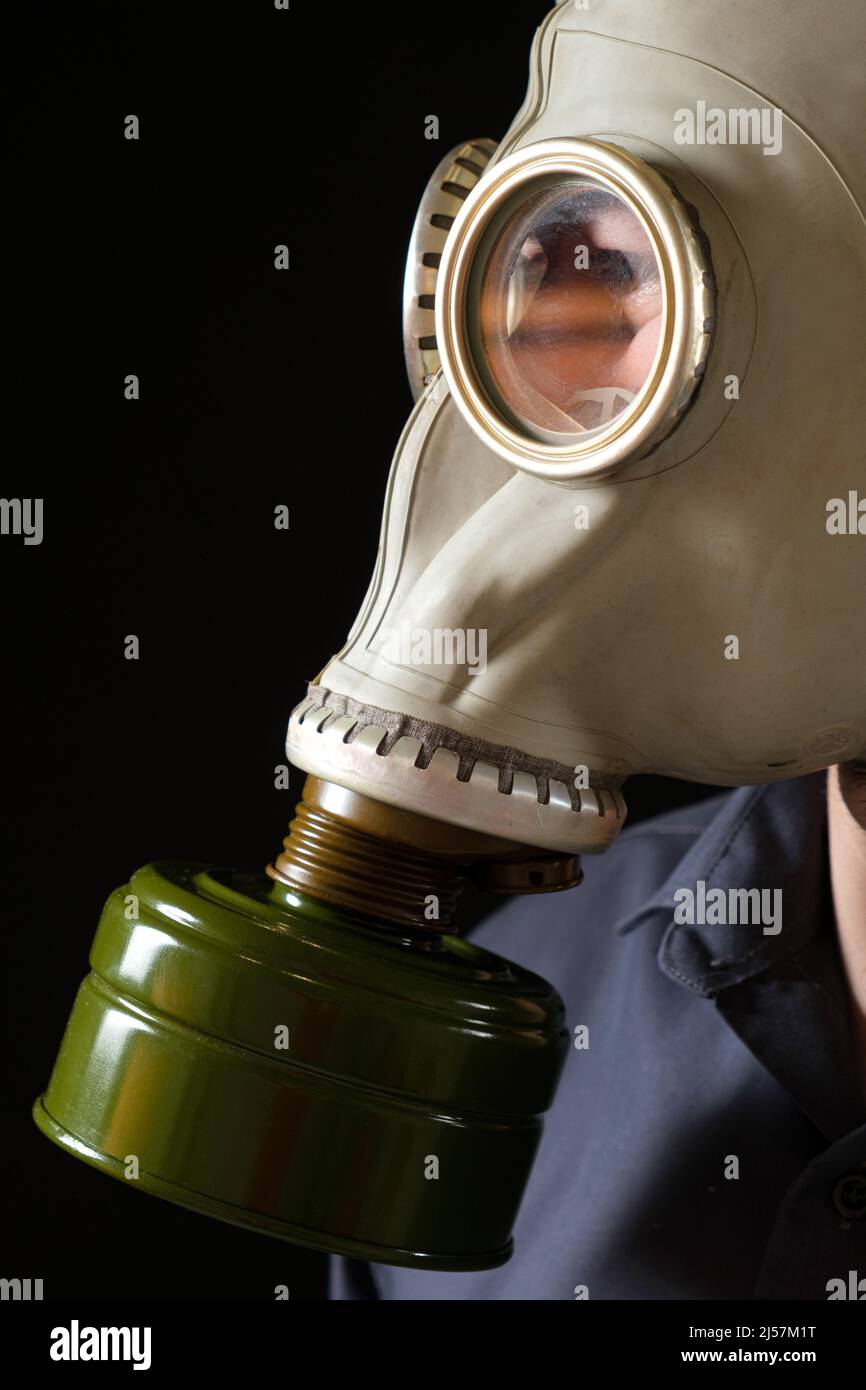 A man in a gas mask on a black background. Chemical weapons, war, gas ...