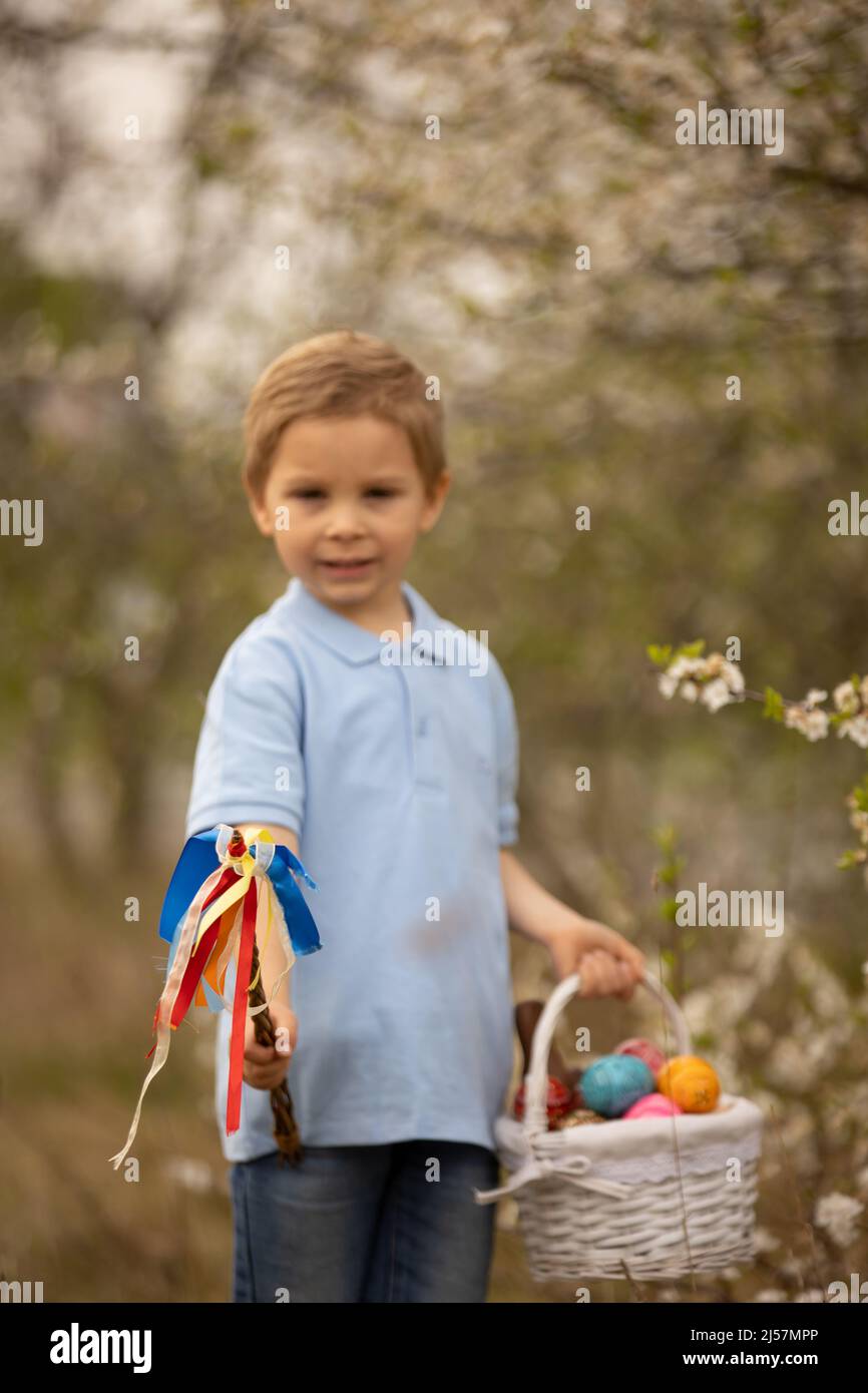Cute preschool child, whipping his sister on Easter with twig, braided ...