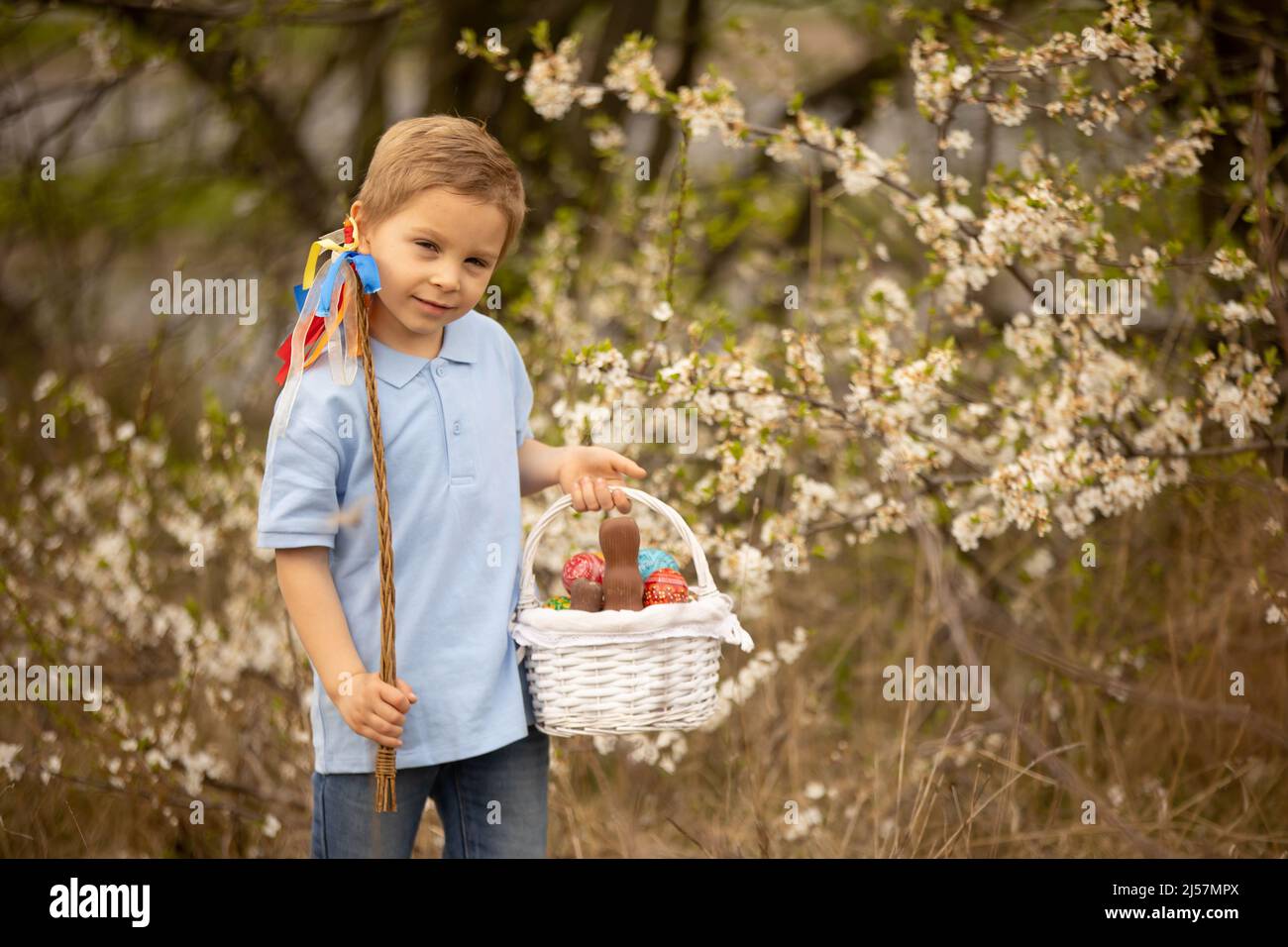 Cute preschool child, whipping his sister on Easter with twig, braided ...