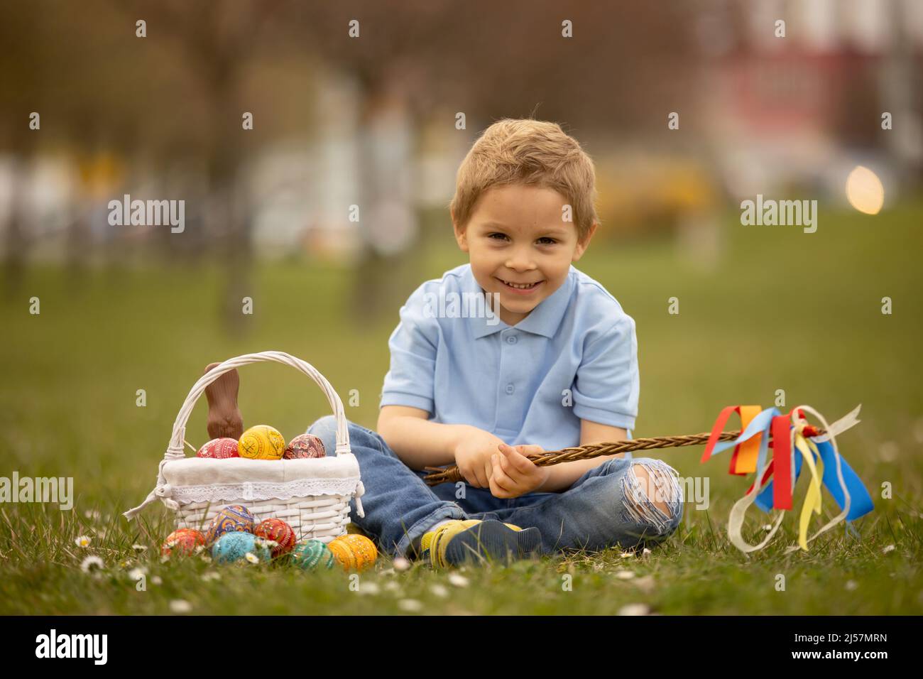 Cute preschool child, whipping his sister on Easter with twig, braided ...