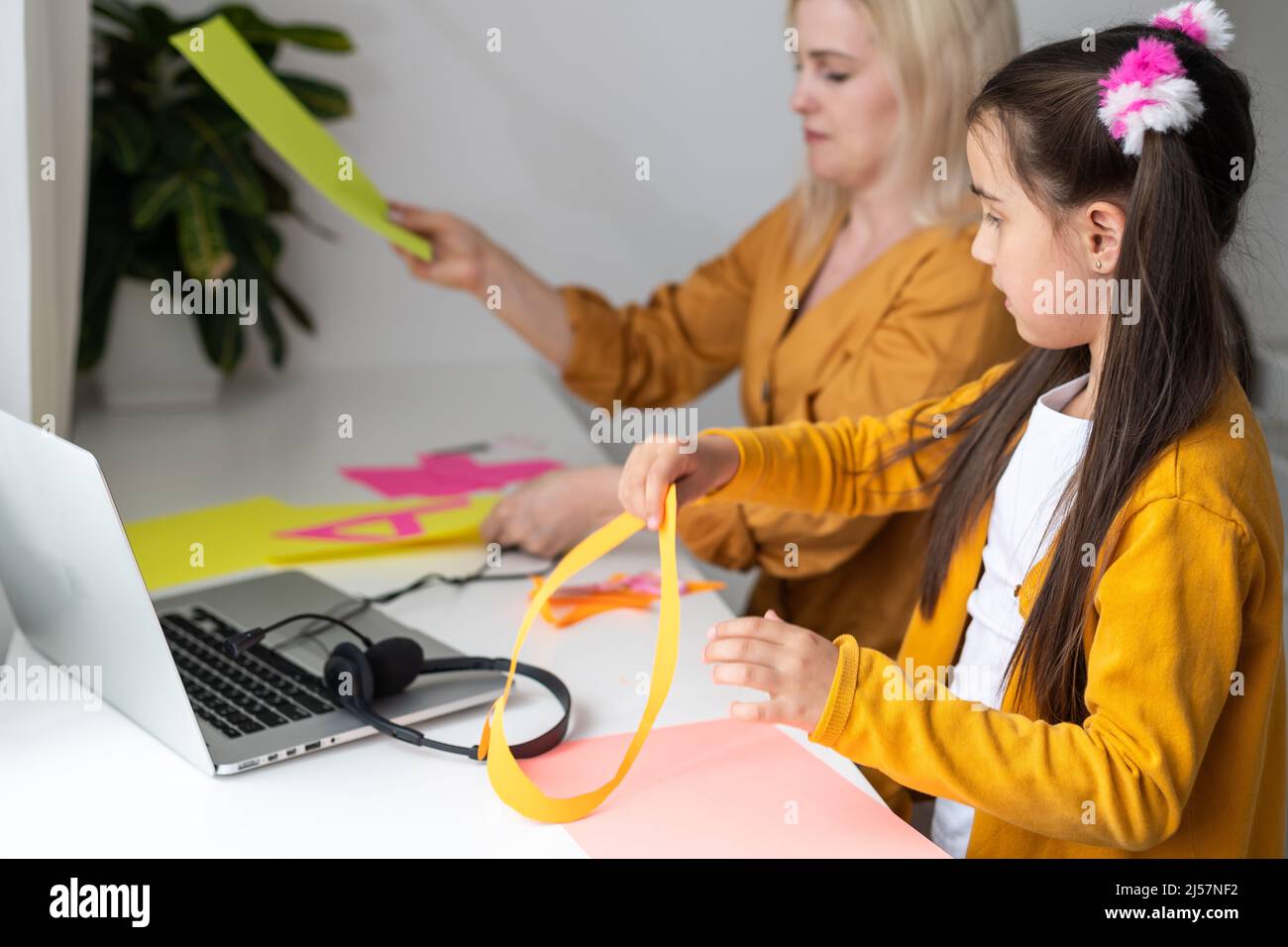 Online education of children. Mother and daughter of preschool watching a video lesson call chat ...