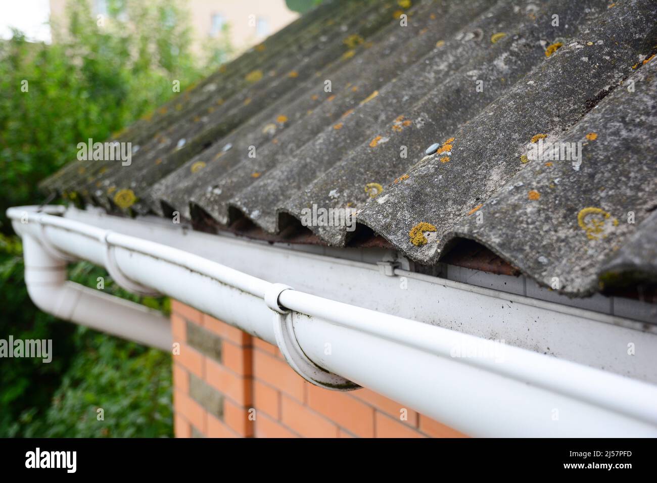 House asbestos roof with close up gutter holder and plastic roof gutter ...