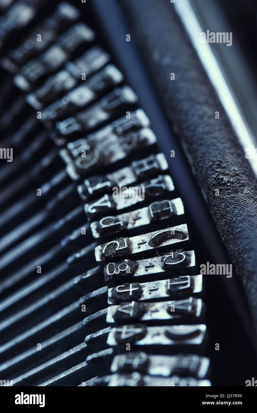 Vertical close-up shot of metal printing letters placed in a typewriter ...