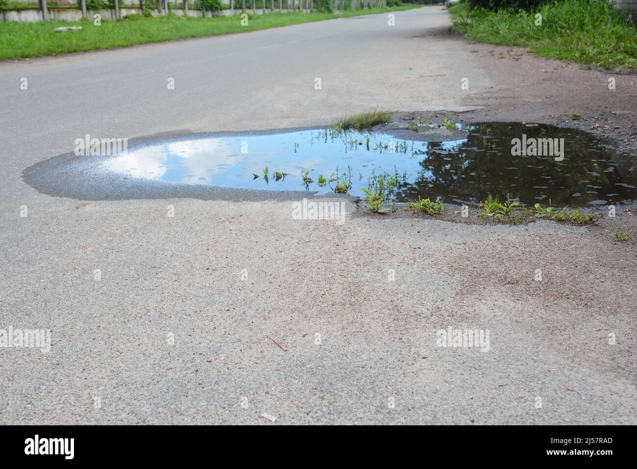 Asphalt road on puddles. Pot hole or pothole image of a broken cracked ...