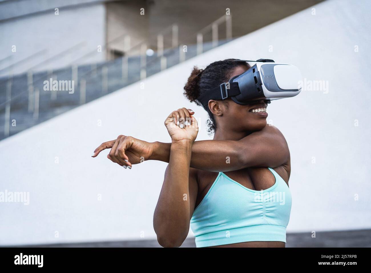 Fit african woman wearing virtual reality headset during workout ...