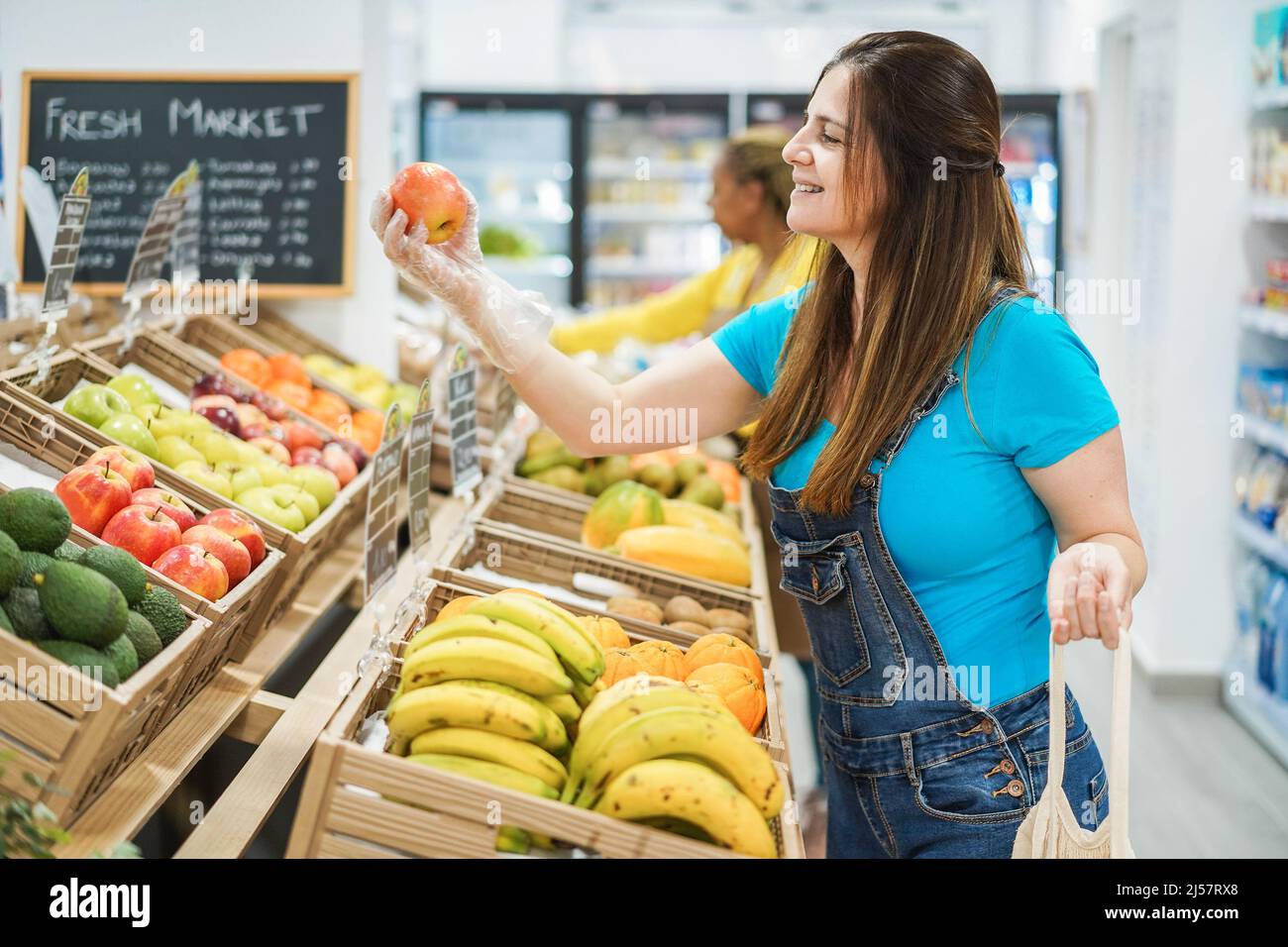 Female customer buying organic food fruits inside eco fresh market ...