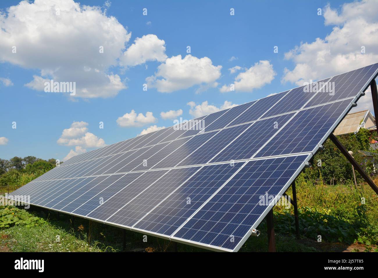 Solar panels with beautiful clouds sky in the garden. Backyard solar ...