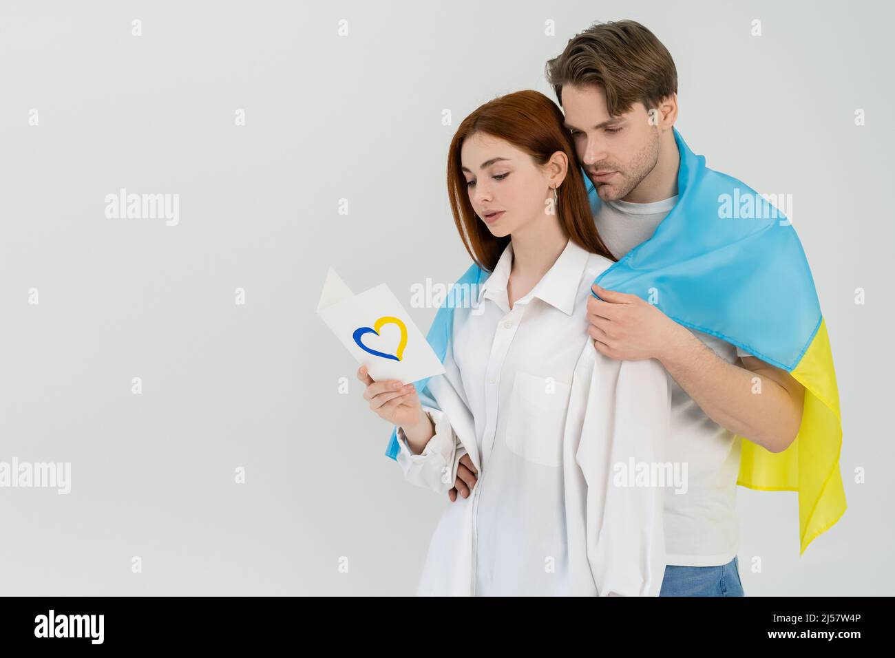 Man in ukrainian flag hugging girlfriend with card heart sign isolated ...
