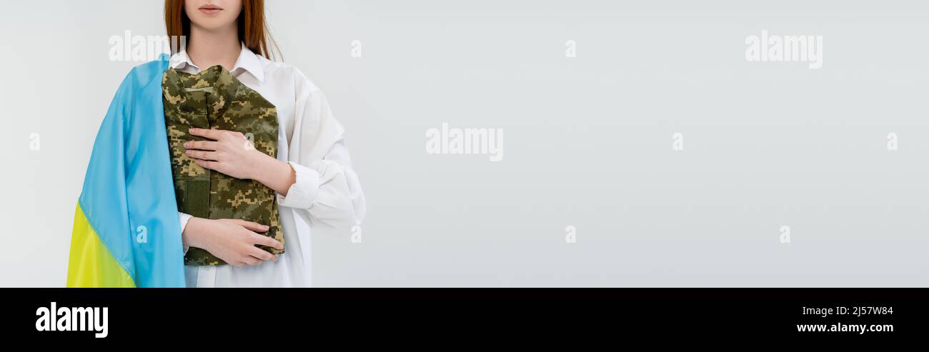 Cropped view of young woman with ukrainian flag hugging military ...