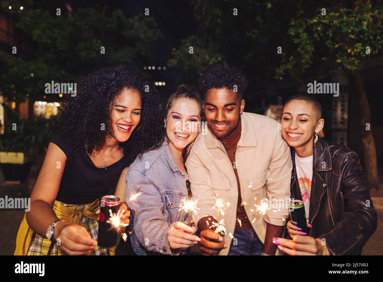 Friends celebrating the holiday season with bengal lights. Group of ...