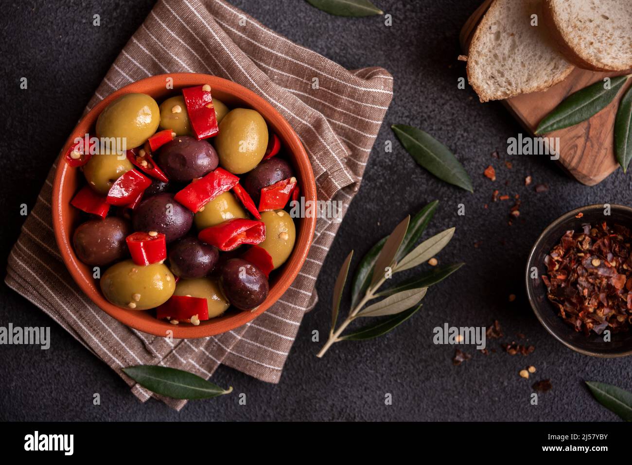 Delicious green and red olives with red chili pepper and olive tree ...