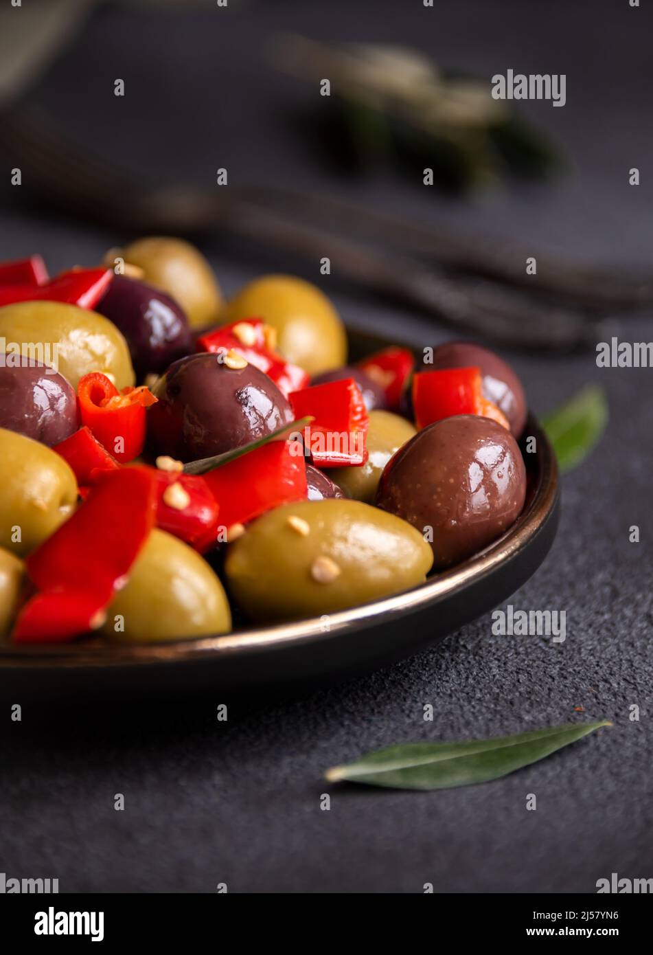 Delicious green and red olives with red chili pepper and olive tree ...