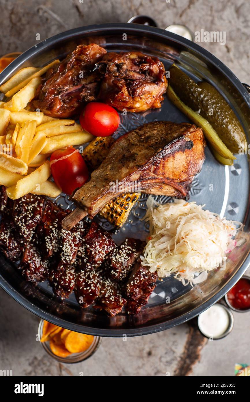 Delicious meats plate, pork ribs, grilled chicken, sausage, beef ...