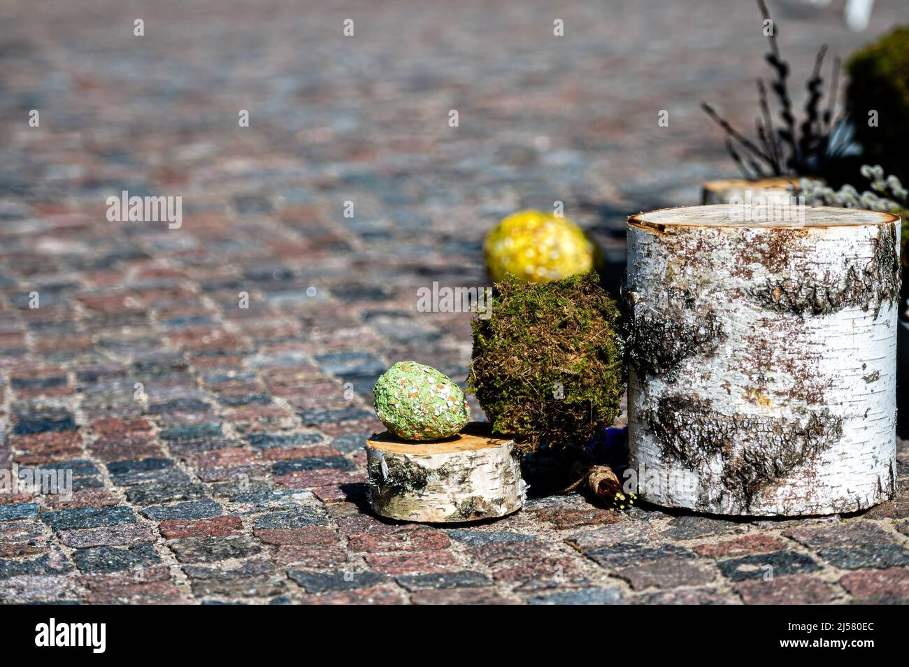 birch blocks, eggs and other Easter decorations on the pavement in the ...