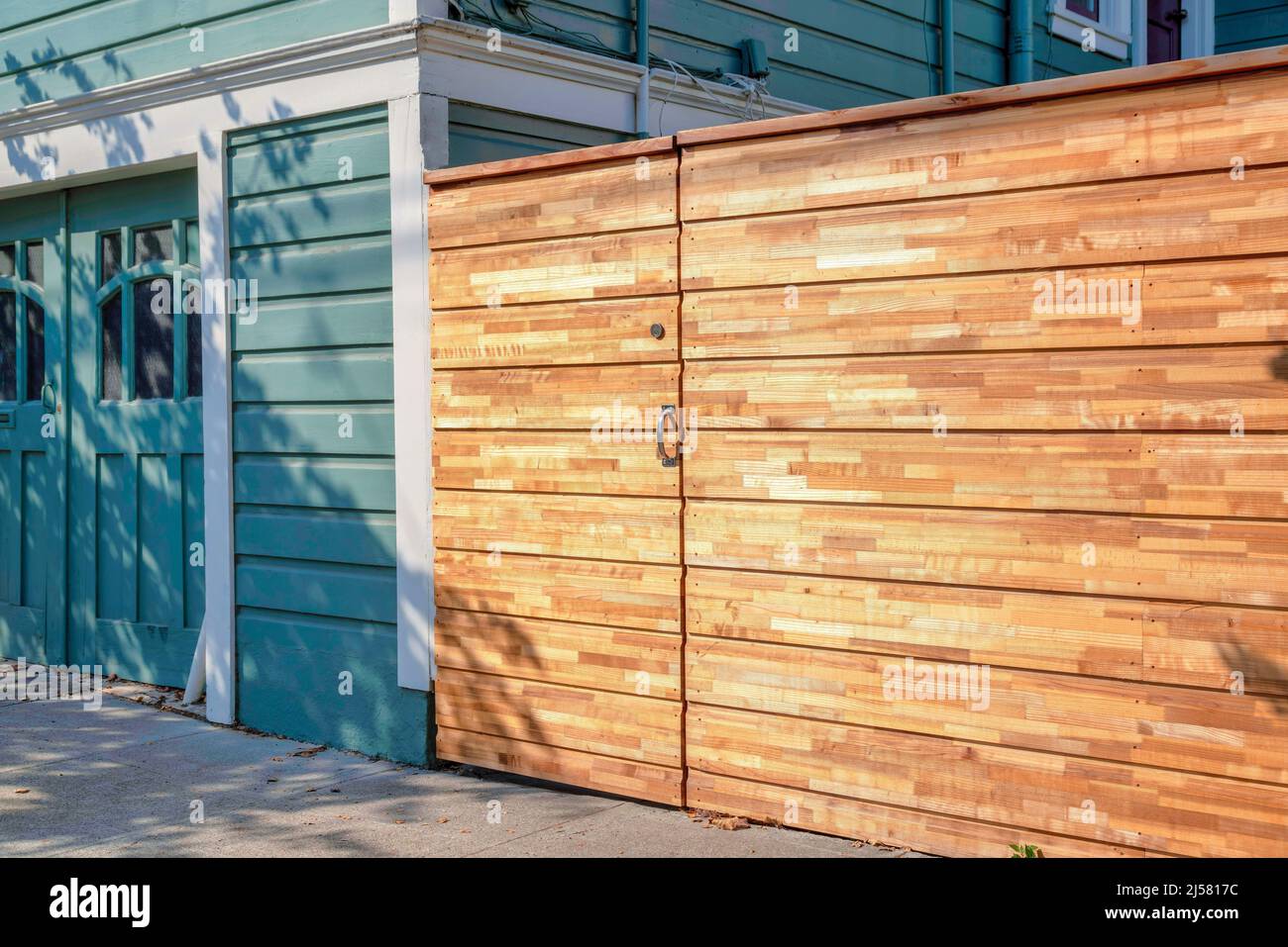 Wooden gate and fence beside the house with blue green exterior at San ...