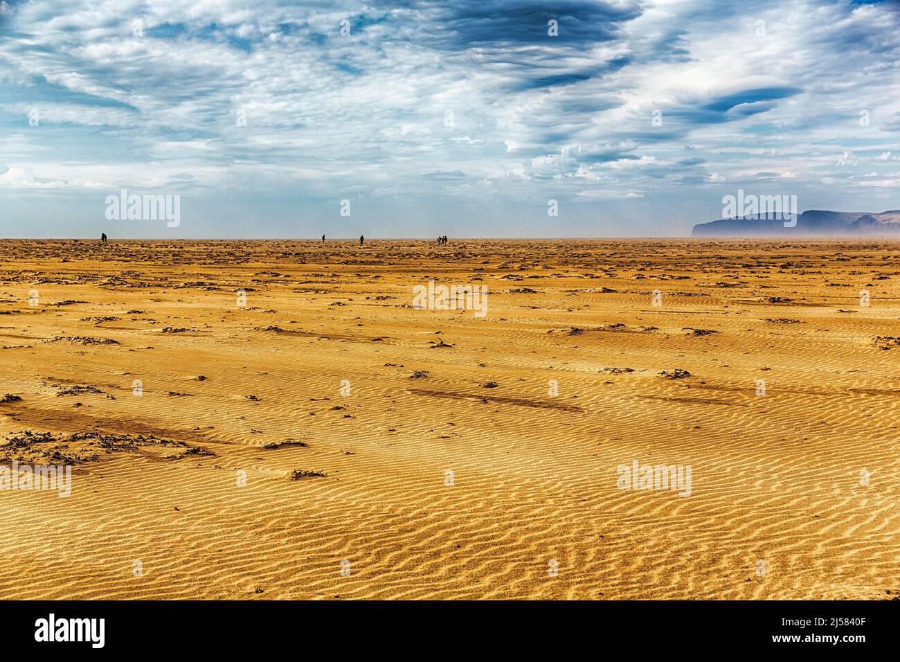 Remote sandy beach, wind-created structures, hikers on the horizon, Red ...