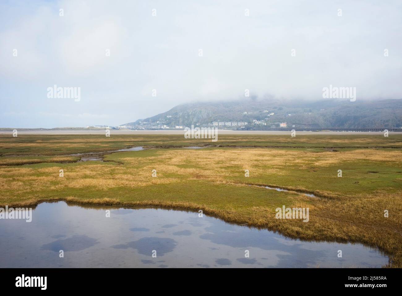 A low mist hangs over Barmouth viewed from the salt marshes across the ...