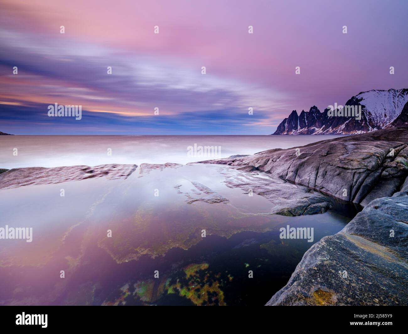 Natural pool on granite beach, Devils Teeth mountain peak in the back ...