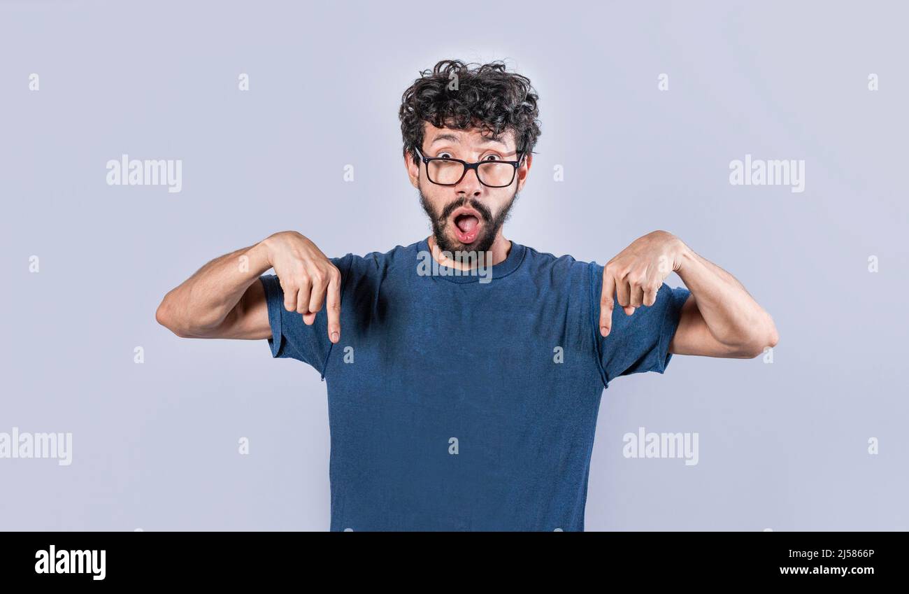 Handsome man pointing down, surprised guy pointing his fingers down ...