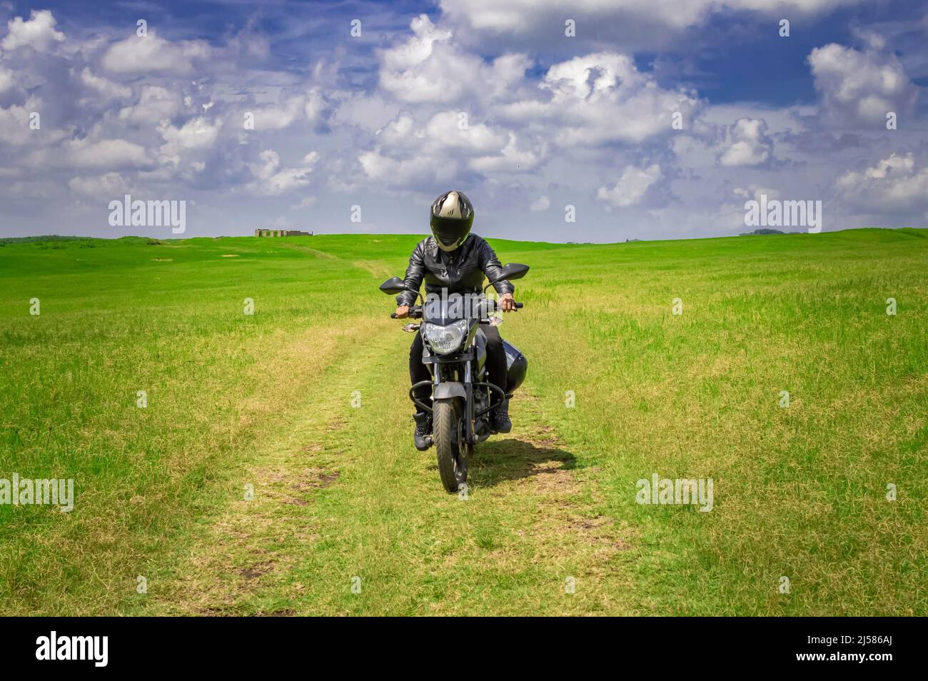 Biker man on a country road, young man on his motorcycle traveling ...