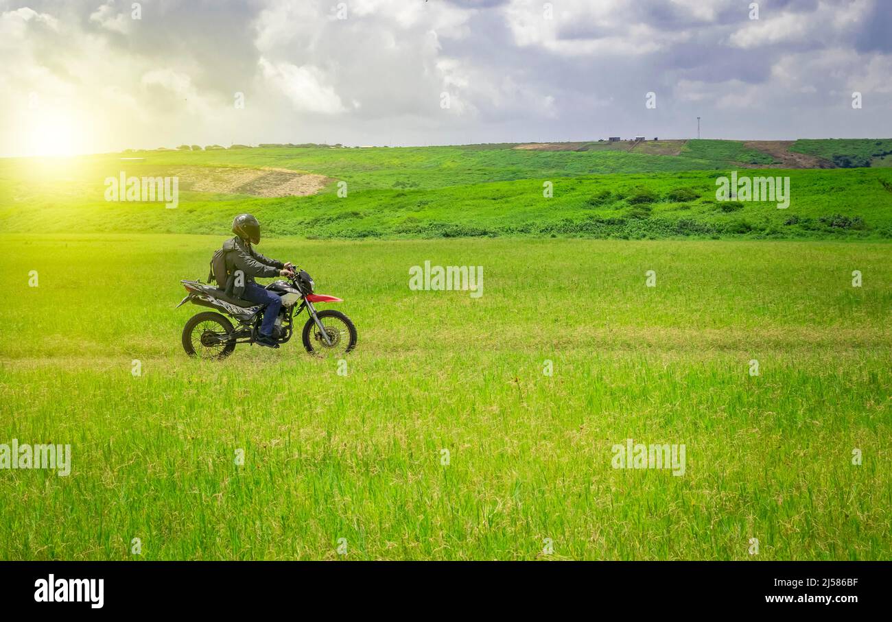 Biker man on a country road, young man on his motorcycle traveling ...