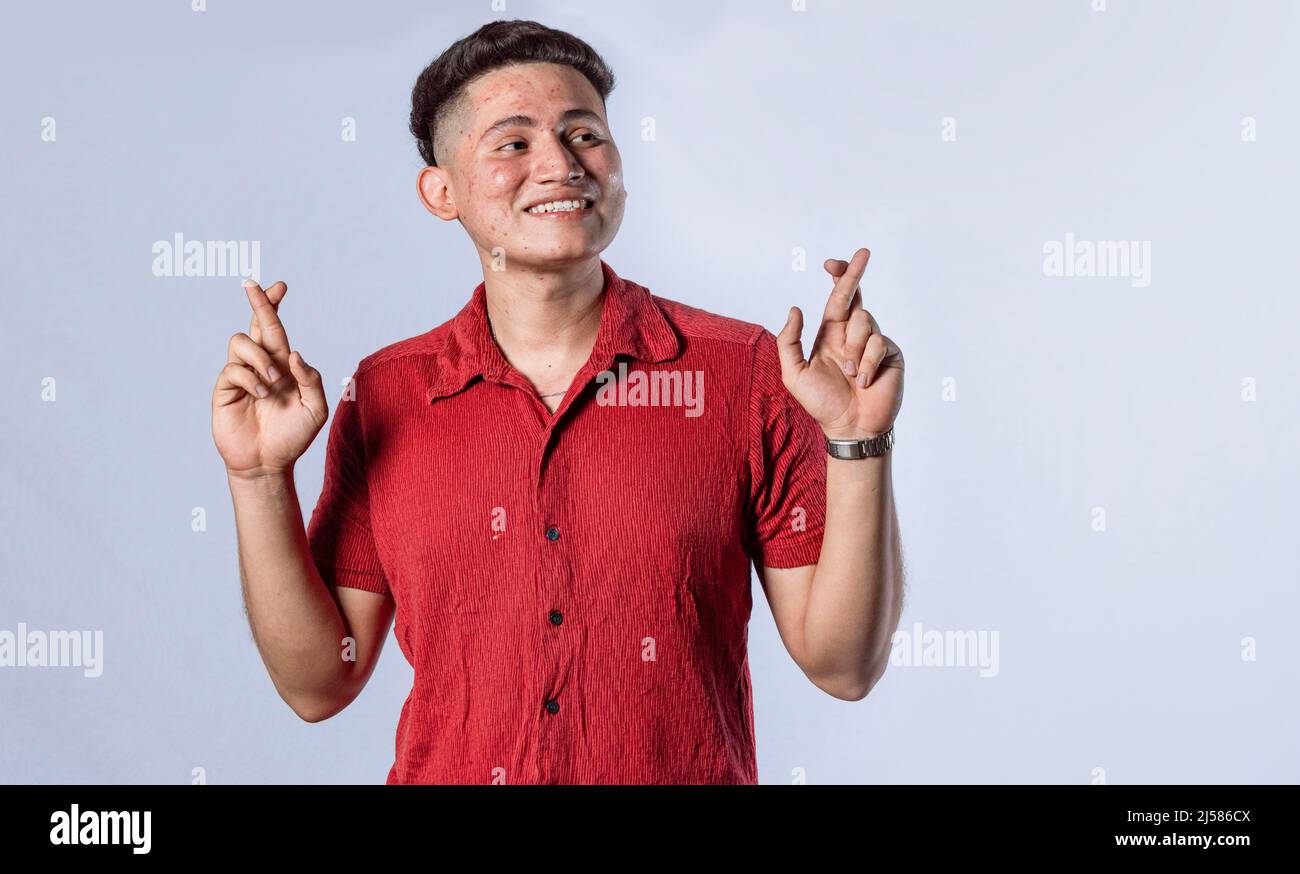 Happy man making a wish, latin guy crossing his fingers making a wish ...