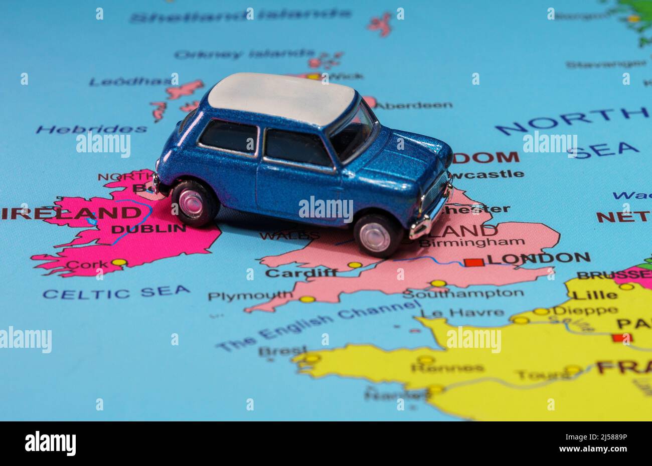 Small toy retro car in the middle of UK map. Travel by car concept ...
