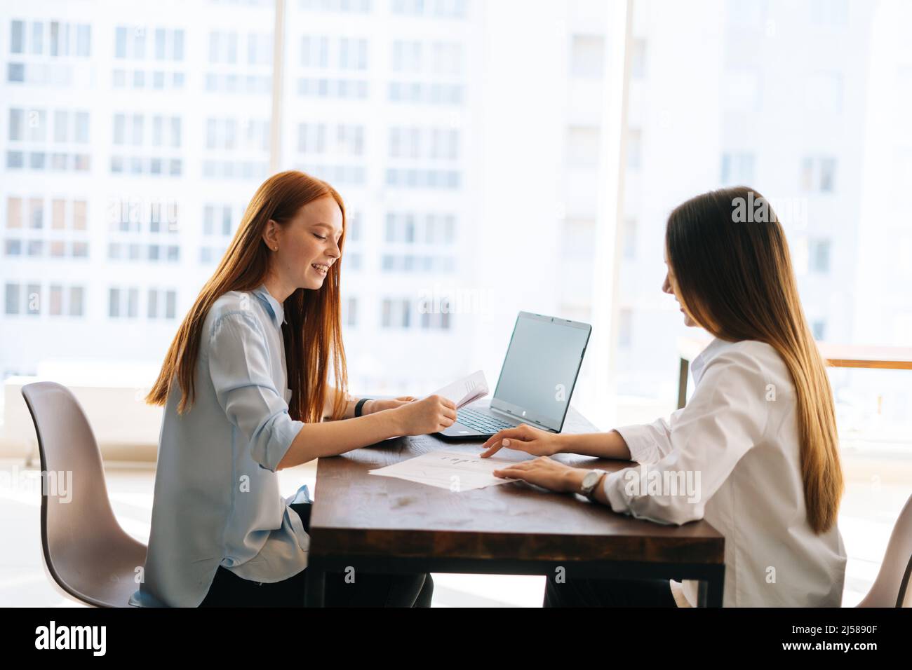 Side View Of Two Businesswomen Discussing New Project Sharing Ideas