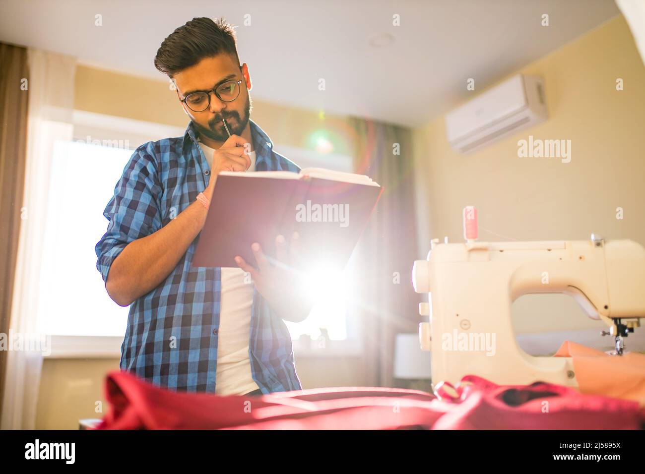 indian man sewing new collection in showroom in living room Stock Photo ...