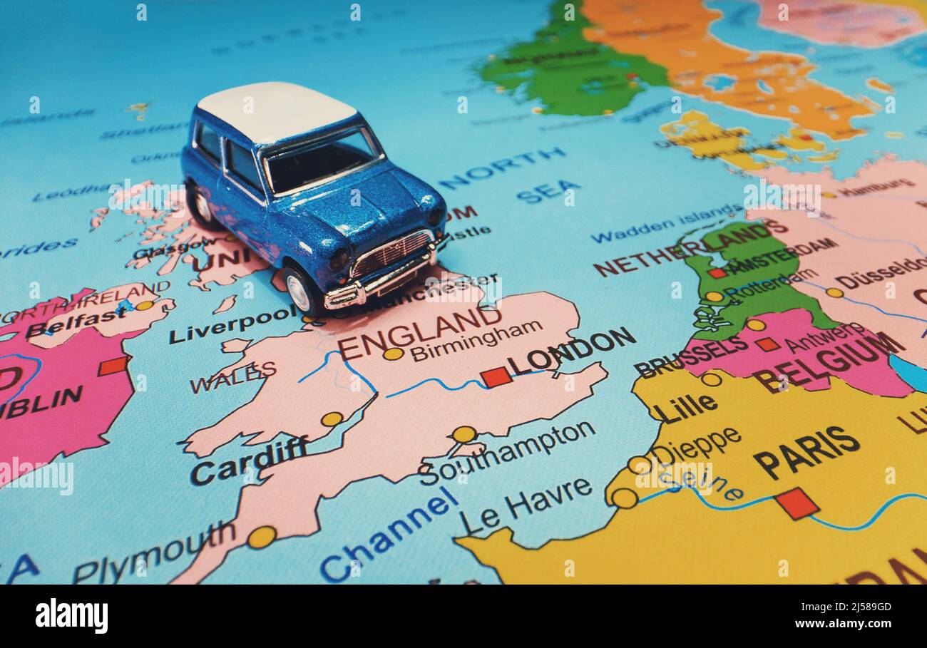 Small toy retro car in the middle of UK map. Travel by car concept ...