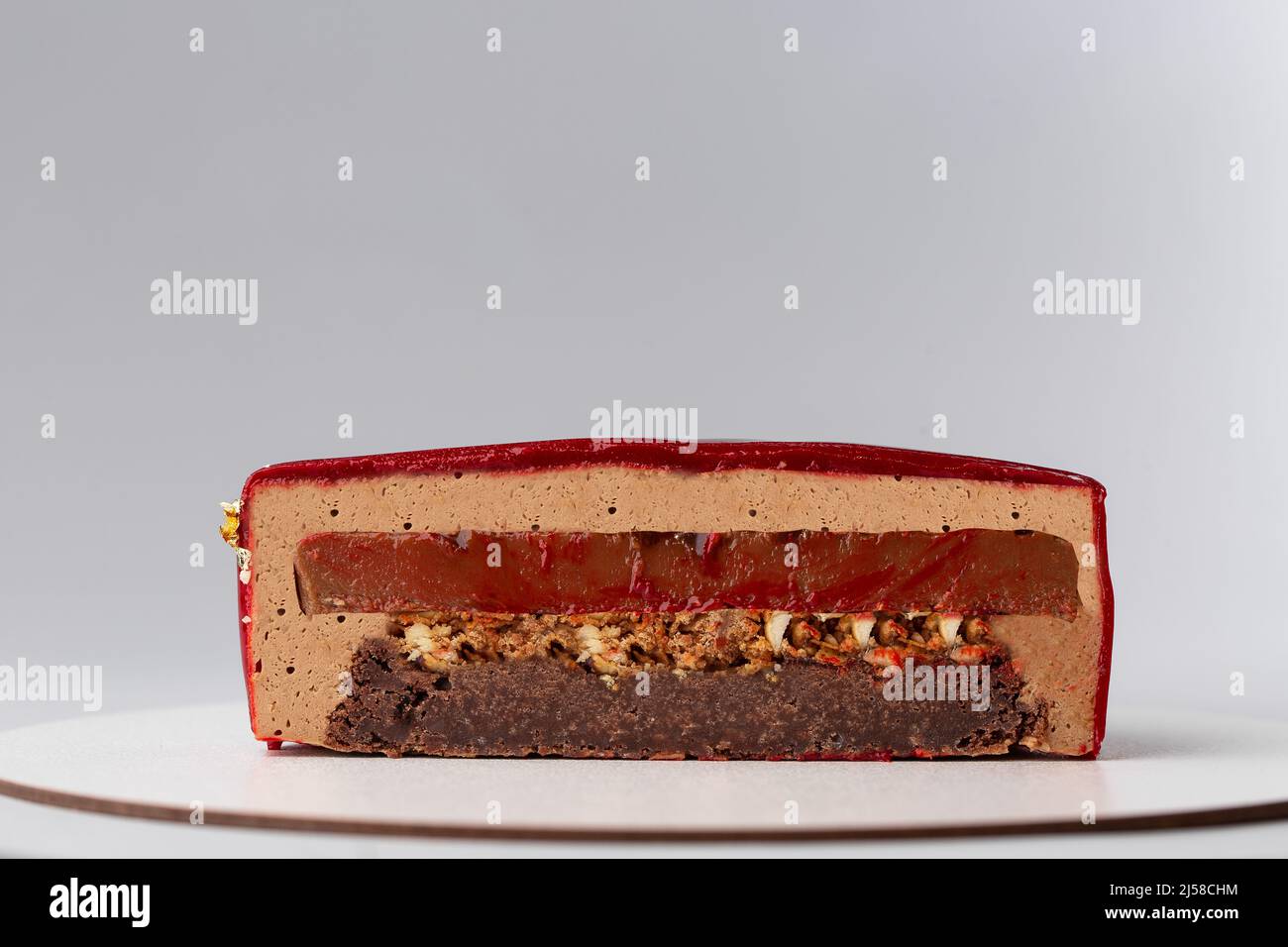 On a white background, a sweet pastry cake is cut in half, the cake is ...